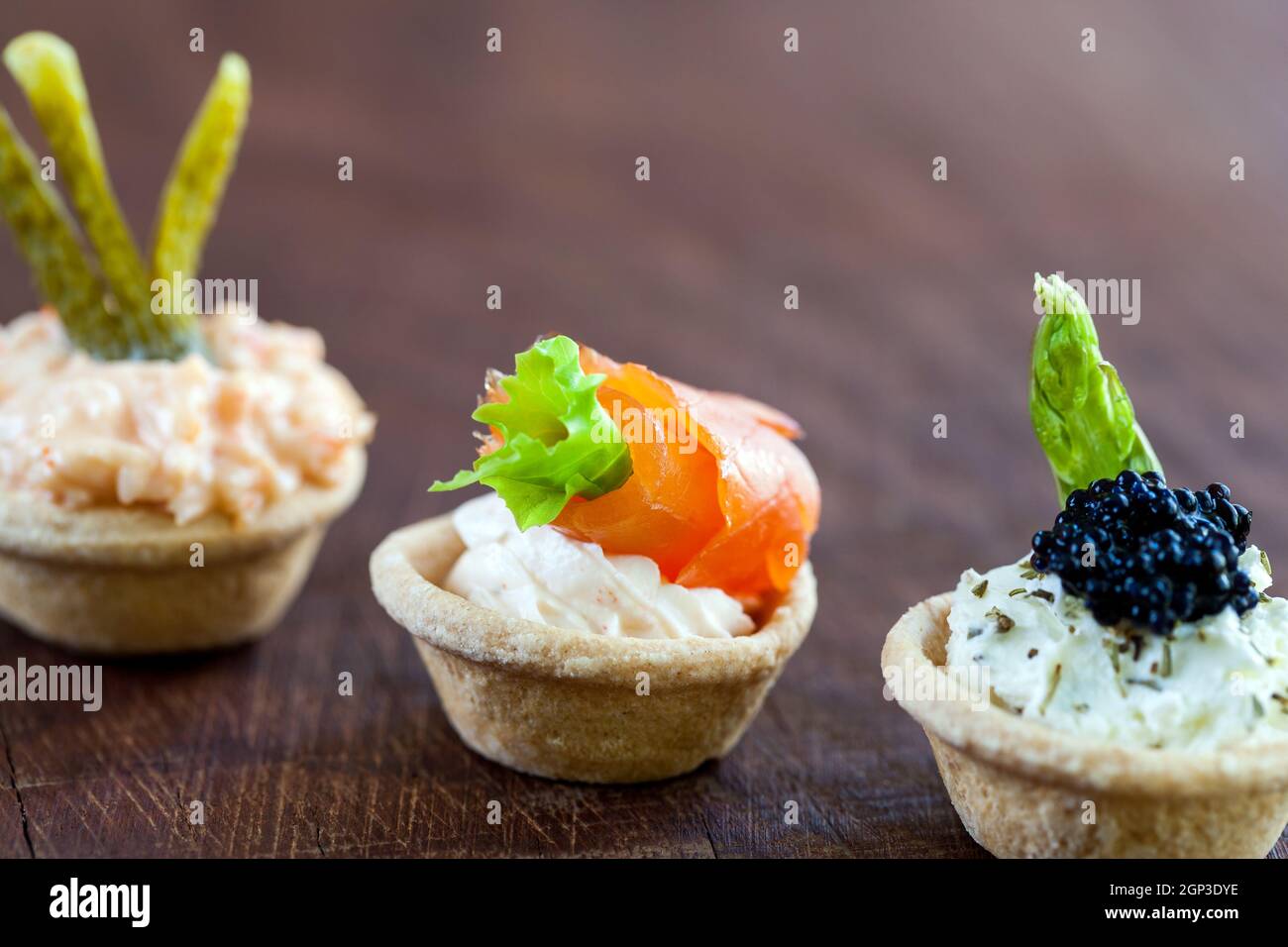 Macro close up of three Mini puff pastry tartlets with seafood filling ...