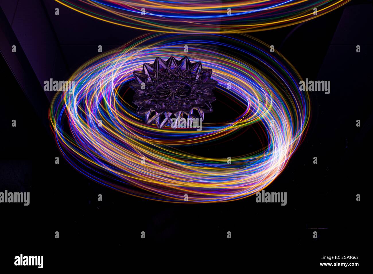 Painting with light on a mirror with small colored lamps and a glass ...