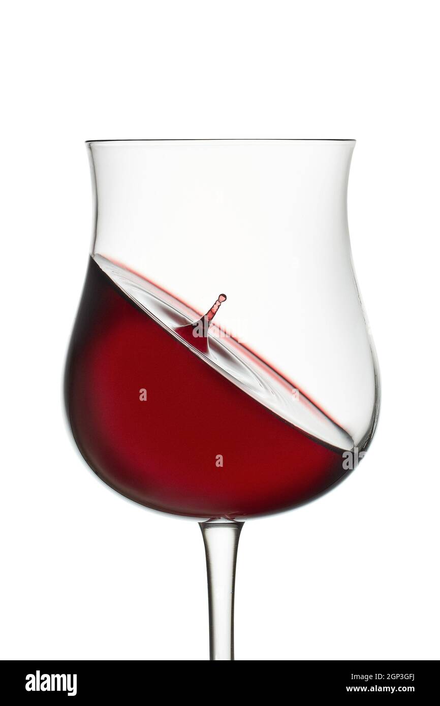 Splashing in glass. Red wine in wineglass isolated on white background ...