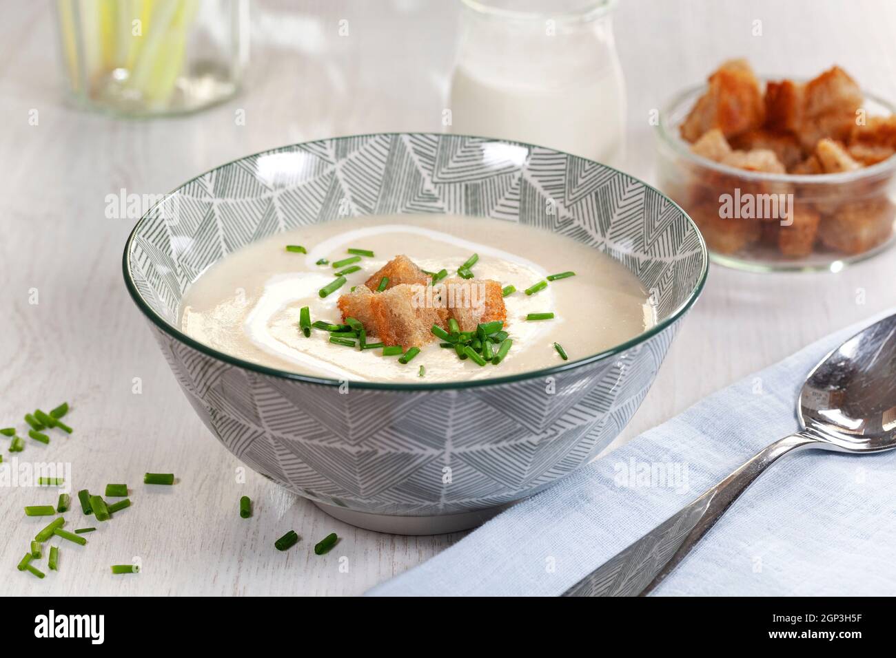 Delicious cream soup with dried croutons and chive on rustic background ...