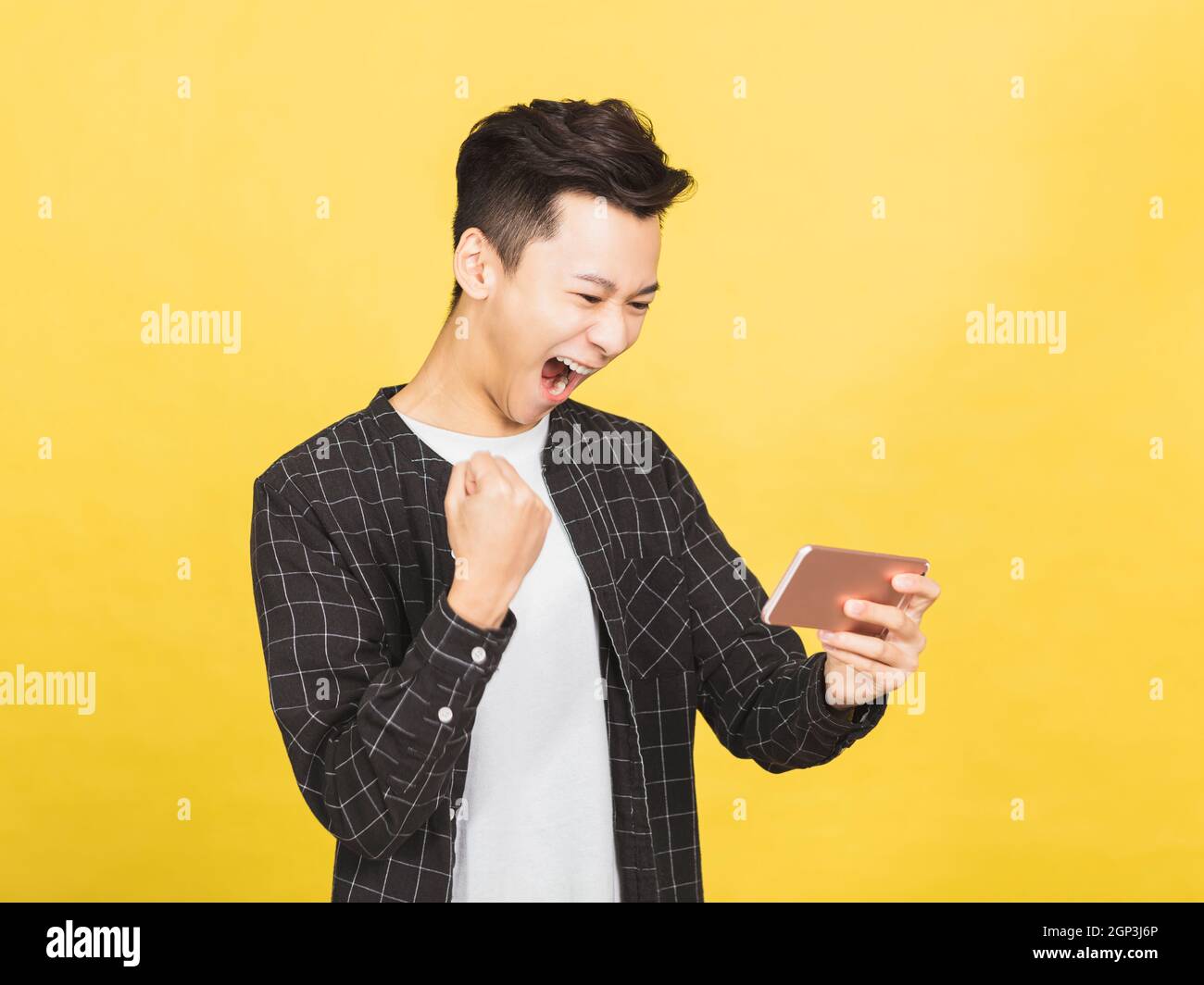 happy young man reading message on his smart phone and celebrating ...