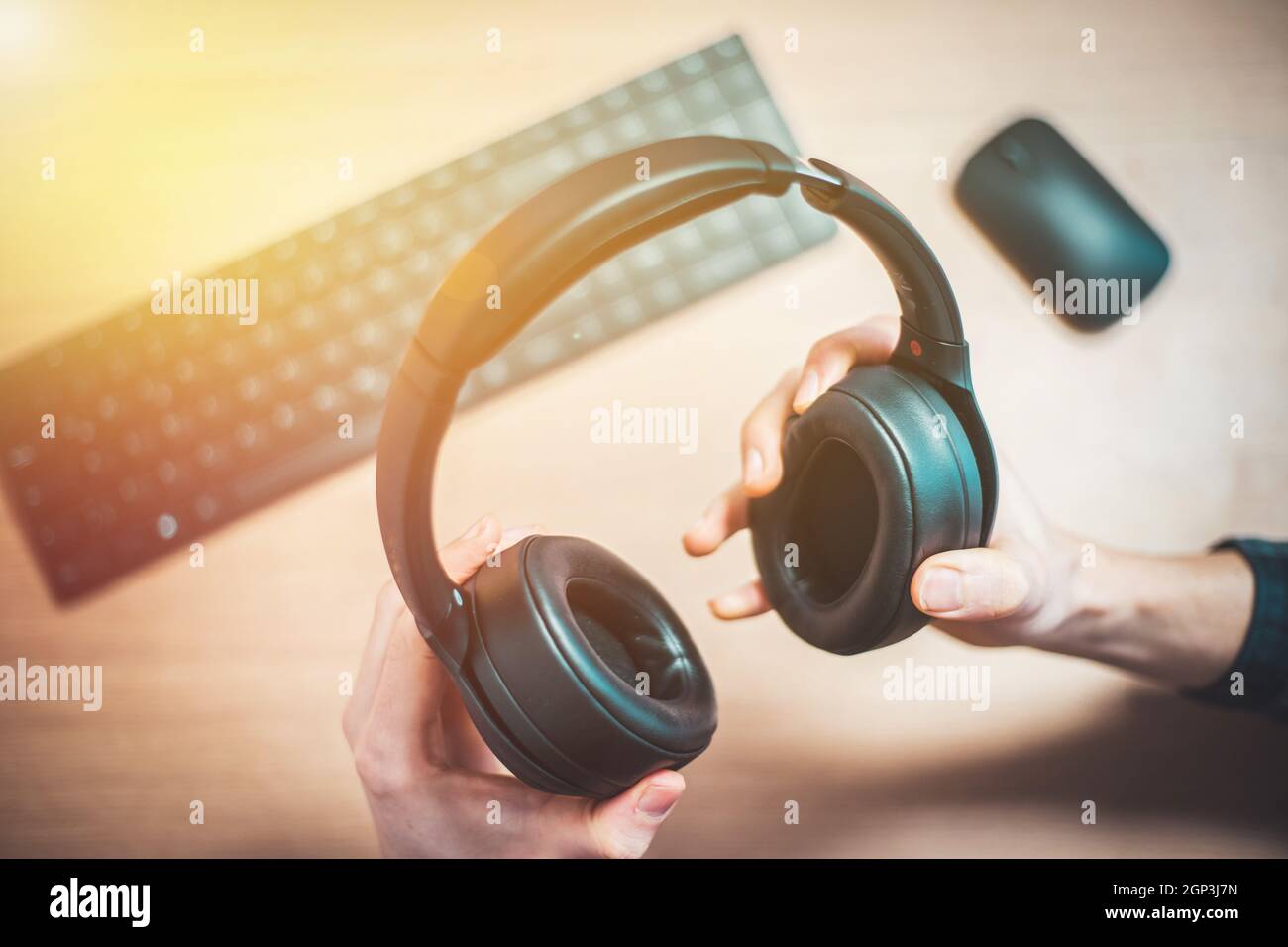 Male hands are holding black wireless headphones, workspace Stock Photo ...