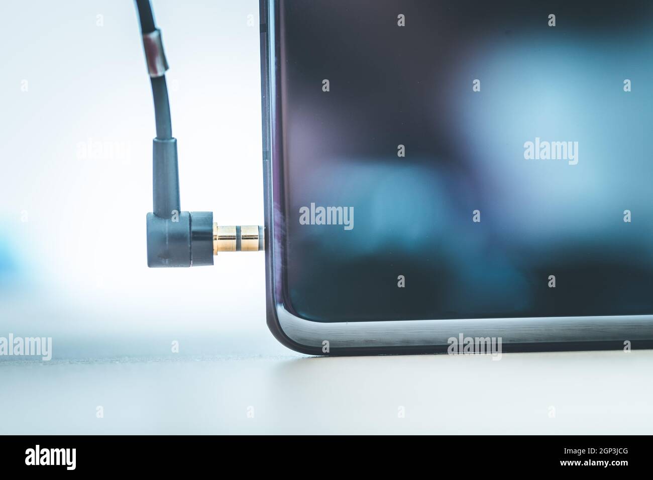 Connection 3.5mm audio jack to a black mobile phone Stock Photo - Alamy