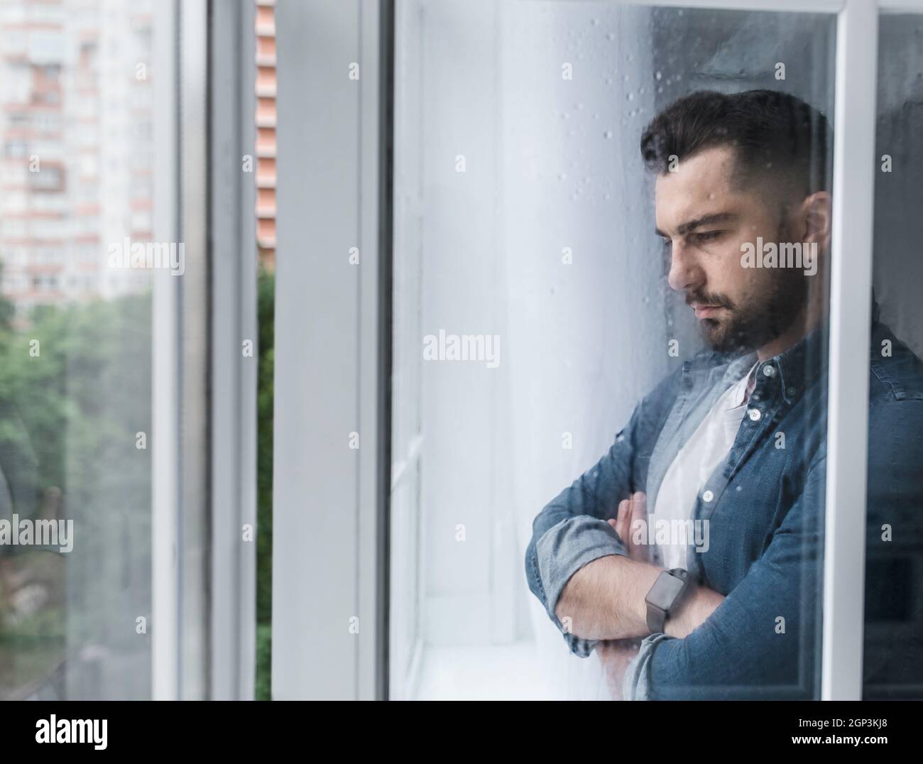 Depressed caucasian man losing job and heartbroken, alone near window ...