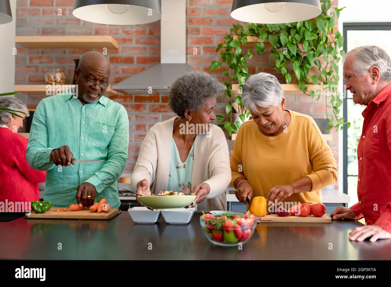 Group of happy diverse senior male and female friends cooking together ...