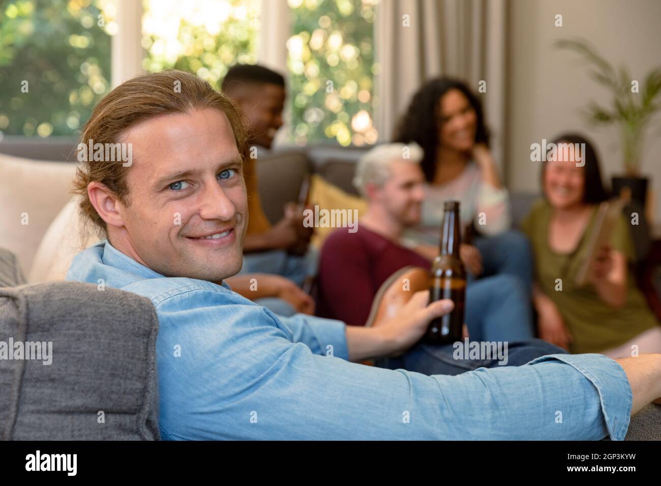 Happy caucasian man holding beer bottle having fun with diverse group ...