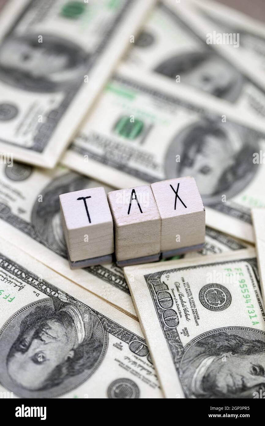 Tax text with hundred dollar bills background, business, financial and ...