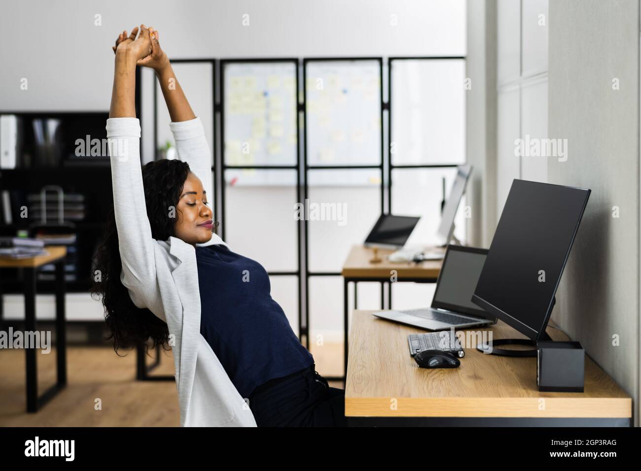American African Doing Stretch Exercise At Work In Office Stock Photo ...