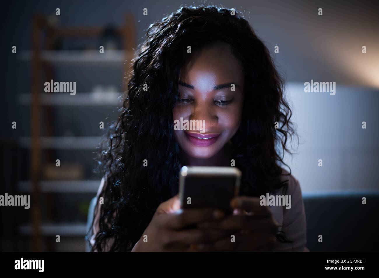 African Woman Using Mobile Phone Or Smartphone In Dark At Night Stock ...