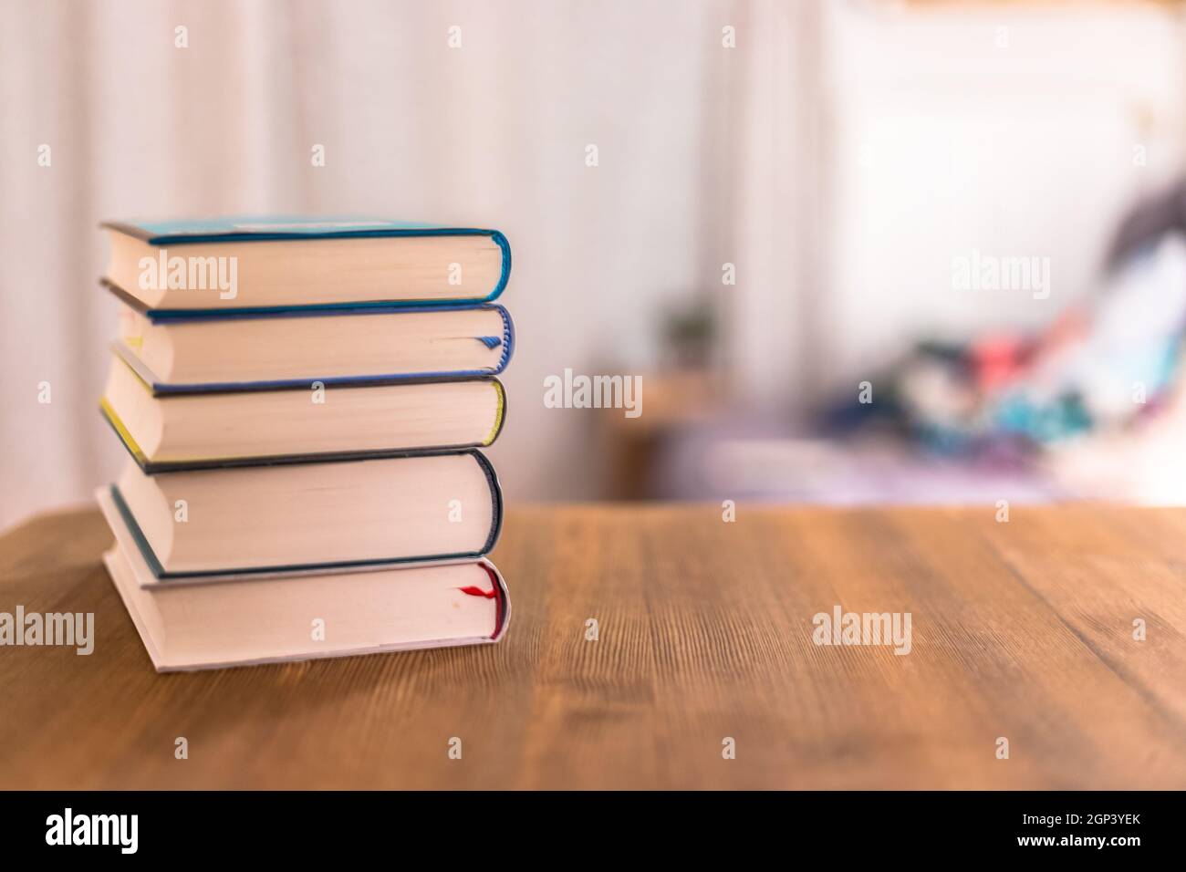 Stack of books lying on wooden desk at home. Knowledge and science ...