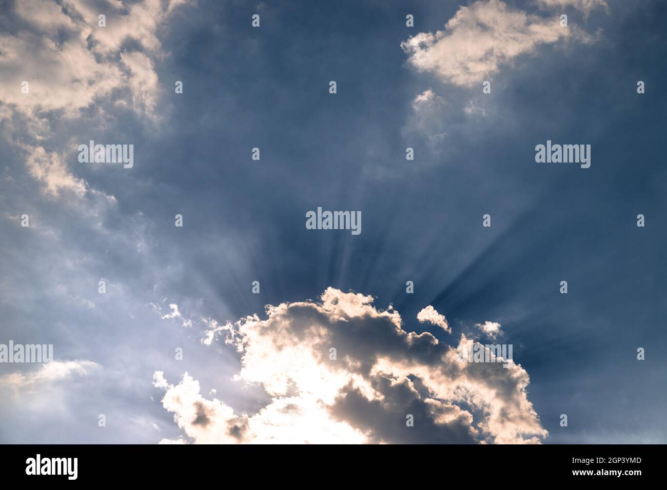 Cloud and bright sunbeams on a blue sky Stock Photo - Alamy