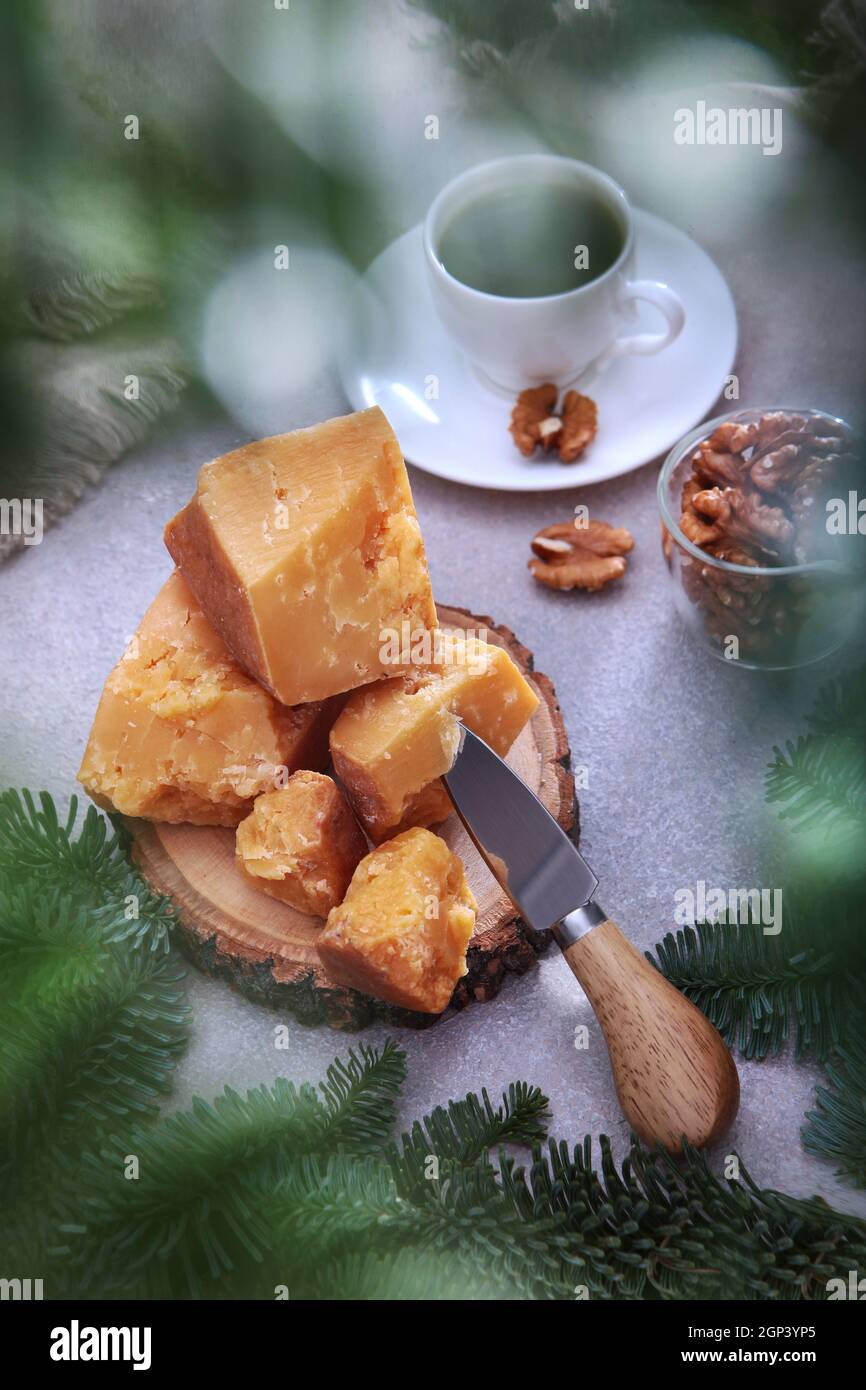 Slices of hard cheese with a cheese knife on a light background ...