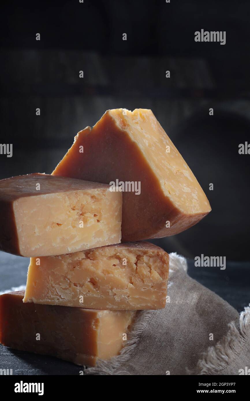Hard cheeses on a dark background. Large chunks of cheese. Vertical ...