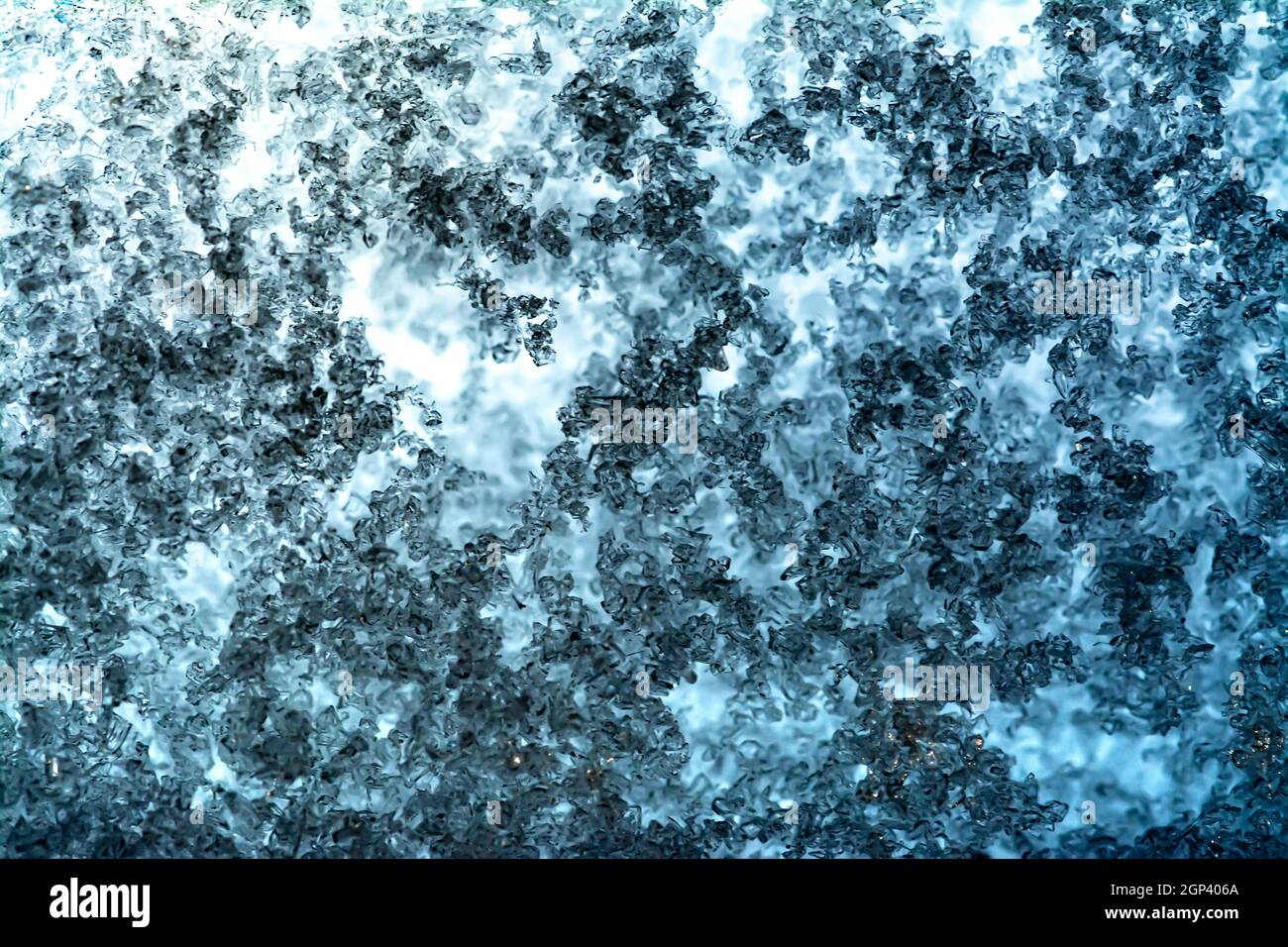 Close-up snow texture on the window with a beautiful gradient in blue ...