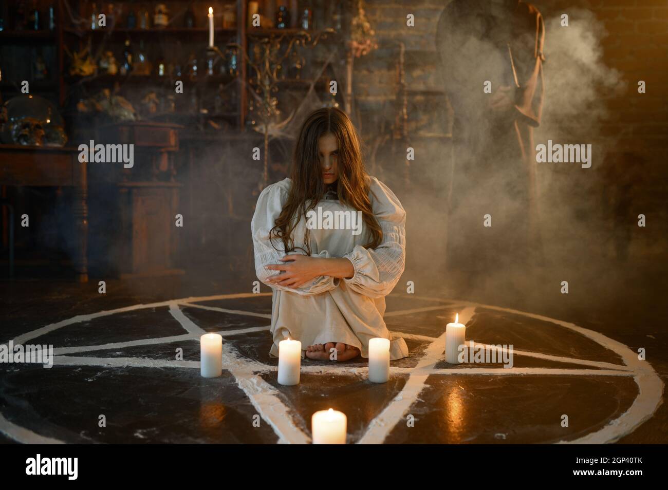 Crazy demonic woman with pumpkin sitting in magic circle with candles ...