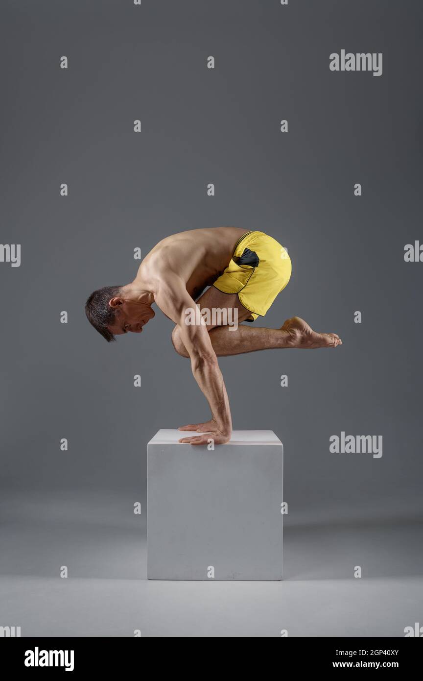 Yoga keeps balanc on hands in difficult pose on the pedestal ...