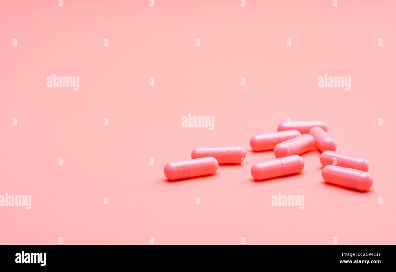 Pink capsule pills on pink background. Valentine's day concept. Pills ...