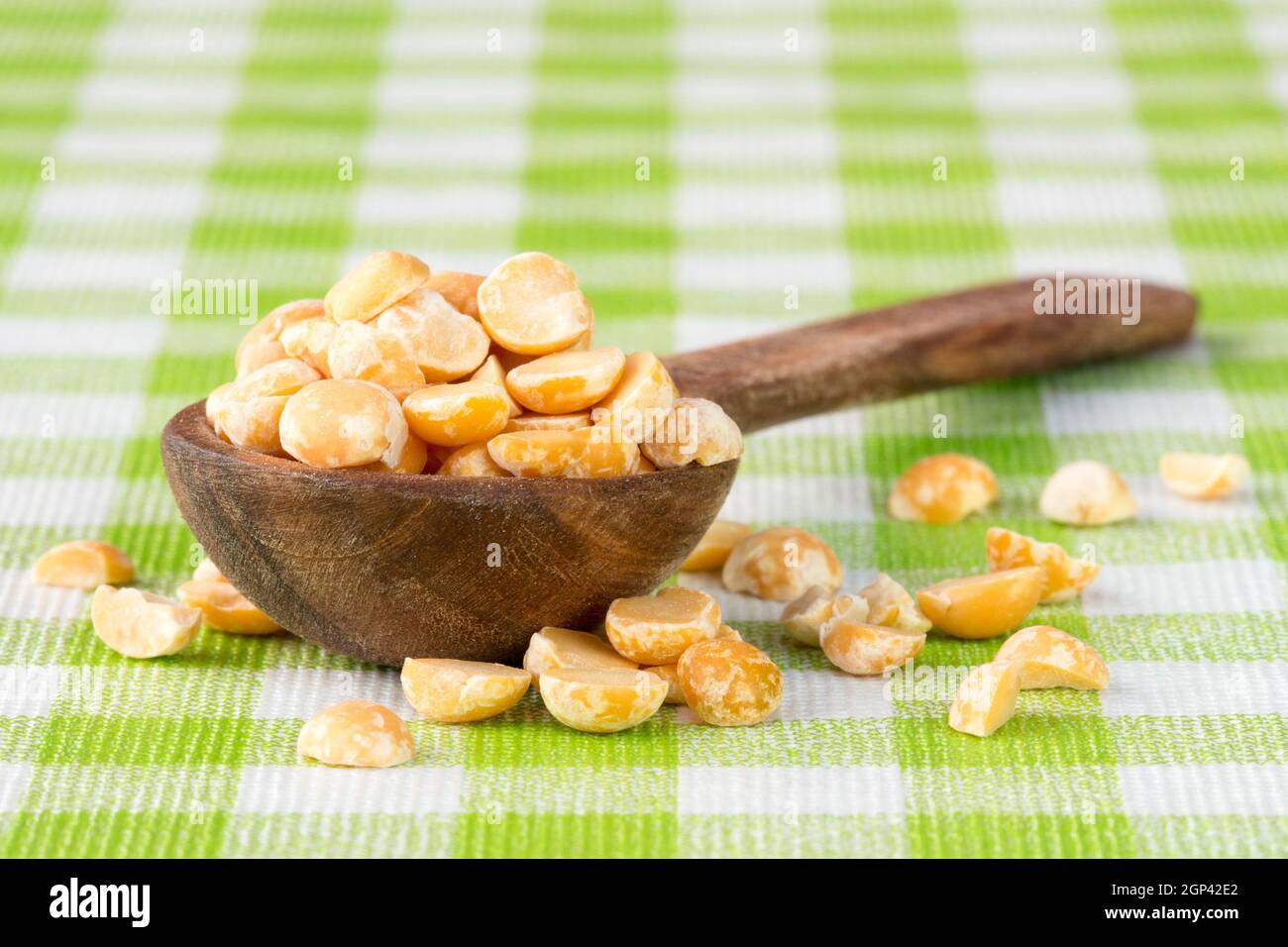 Raw split peas in a wooden spoon on checkered tablecloth Stock Photo ...