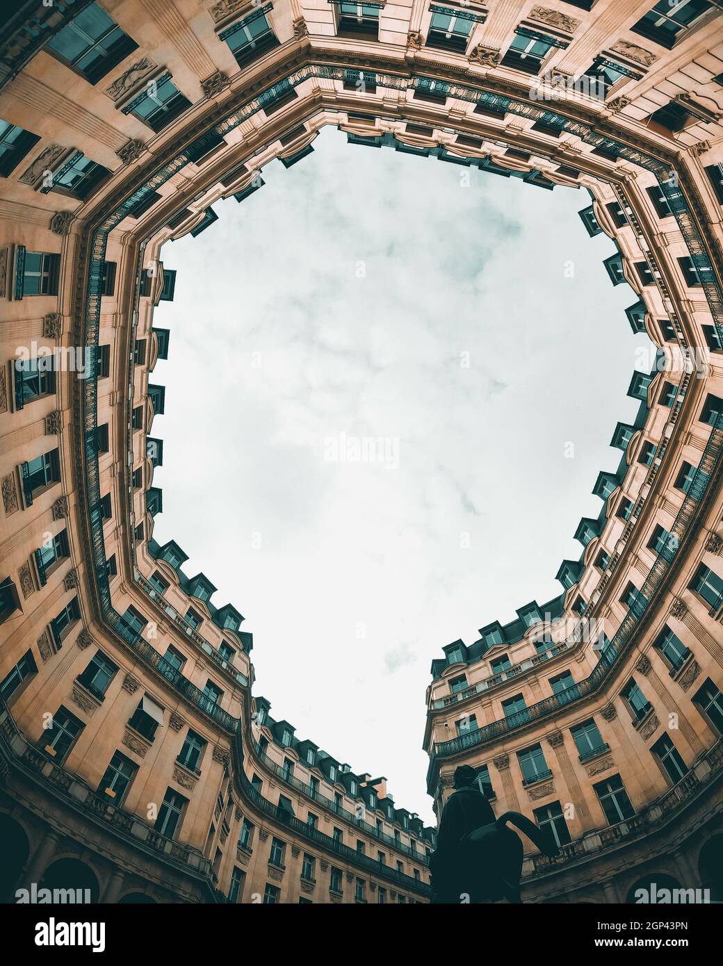 Vertical low angle shot of historic buildings on cloudy sky background ...