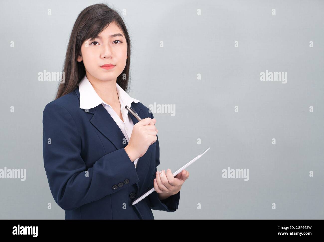 Woman in suit using computer digital tablet isolate on gray background ...