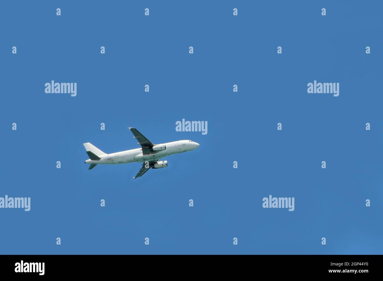 Plane flying high in sky. View to air liner flying in blue sky ...