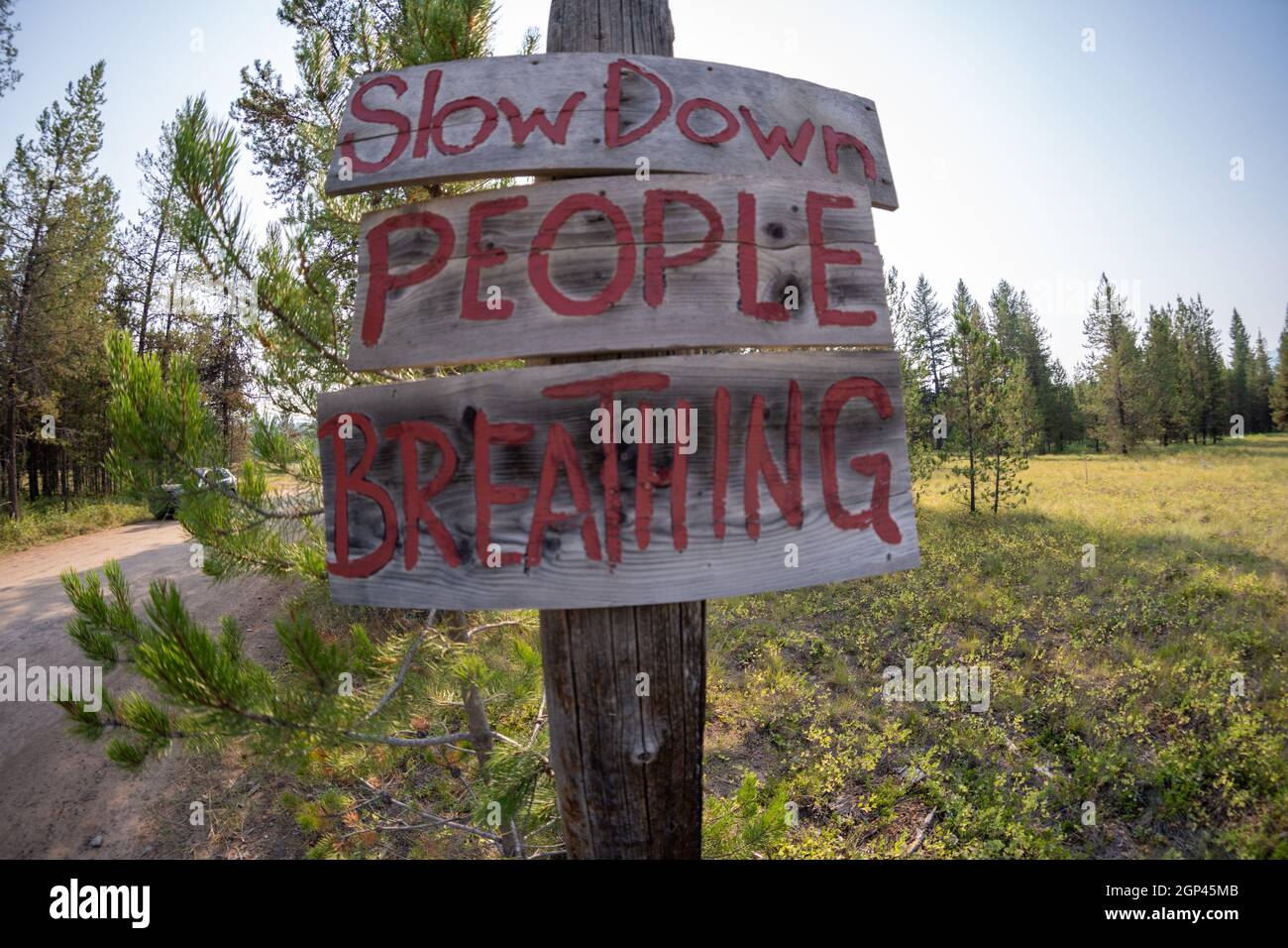 Sign - Slow Down People Breathing along a dirt word to prevent ...