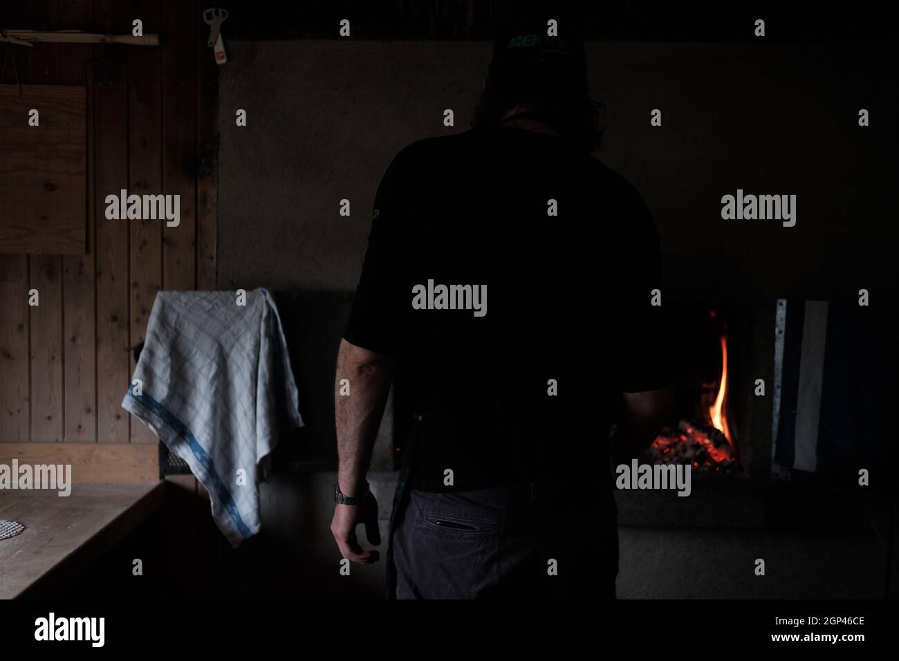 Lonely man walking to the fireplace in a room Stock Photo - Alamy
