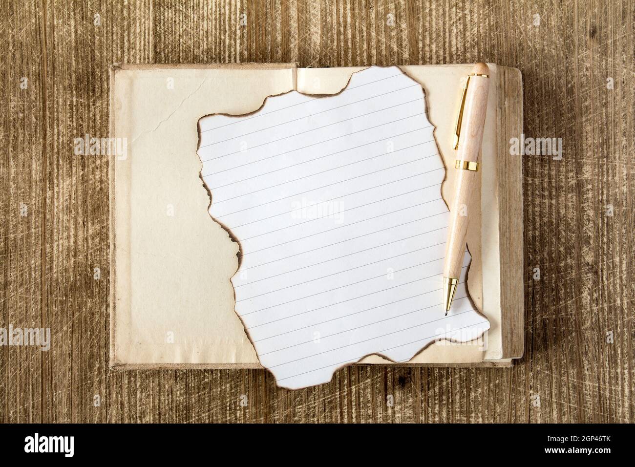 Old book with burned letter on the wooden background Stock Photo - Alamy