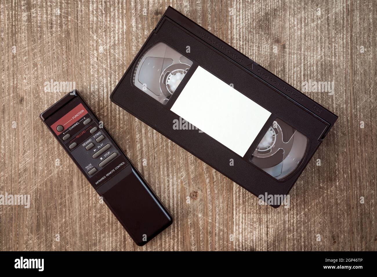 VHS video tape cassette and remote control on wooden background.Copy ...