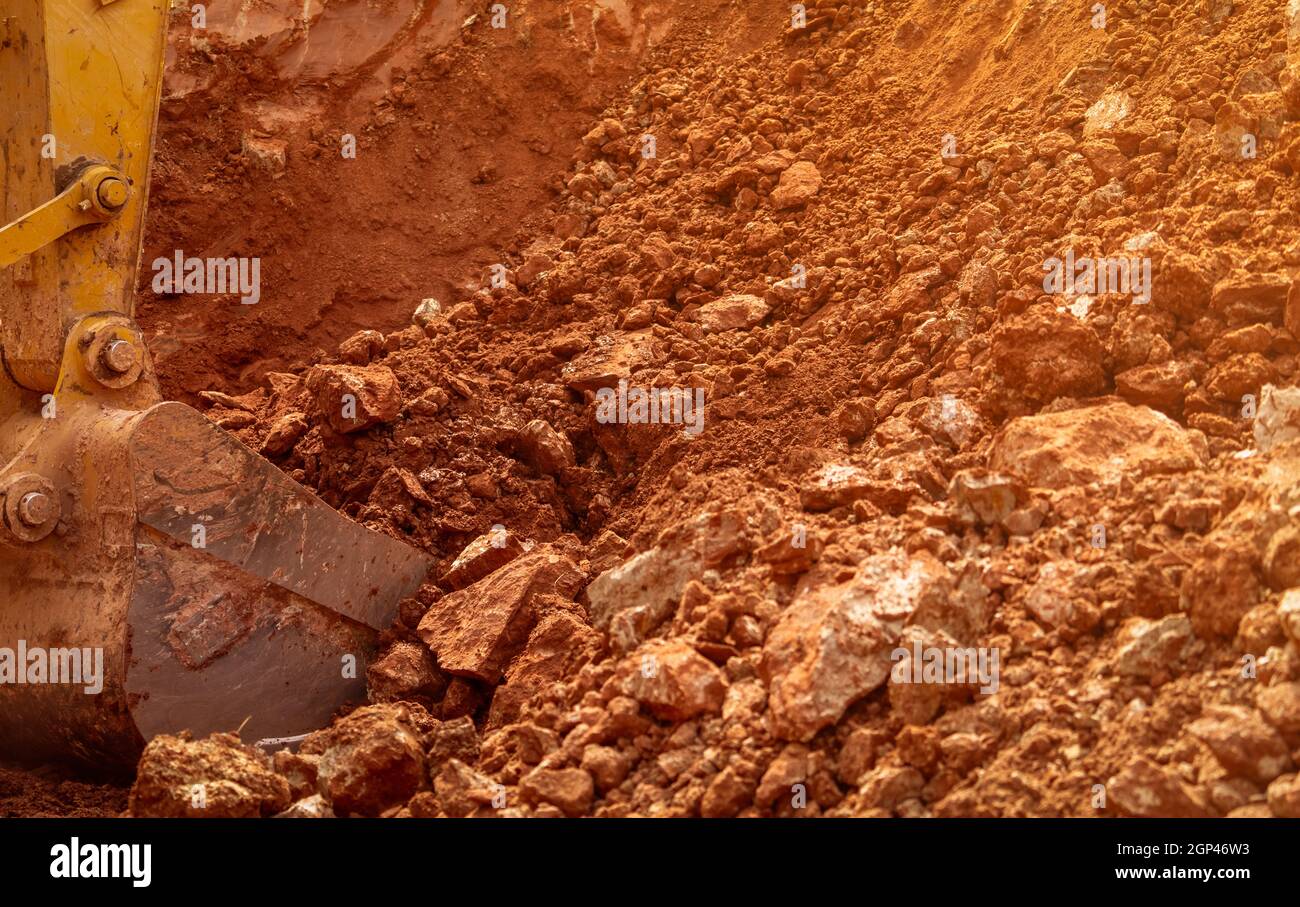 Backhoe bucket digging the soil at agriculture farm to make pond ...