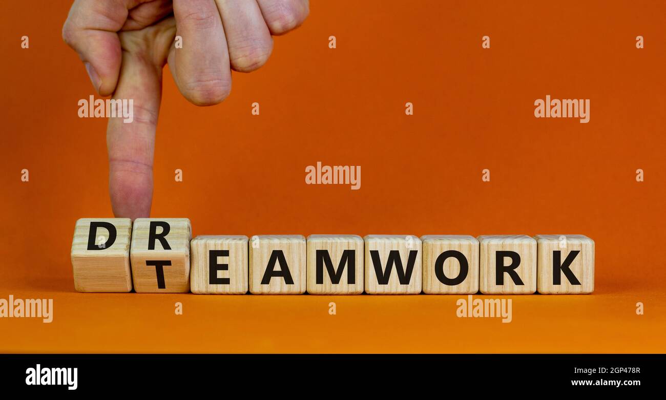 Teamwork and dream work symbol. Businessman turns wooden cubes and ...