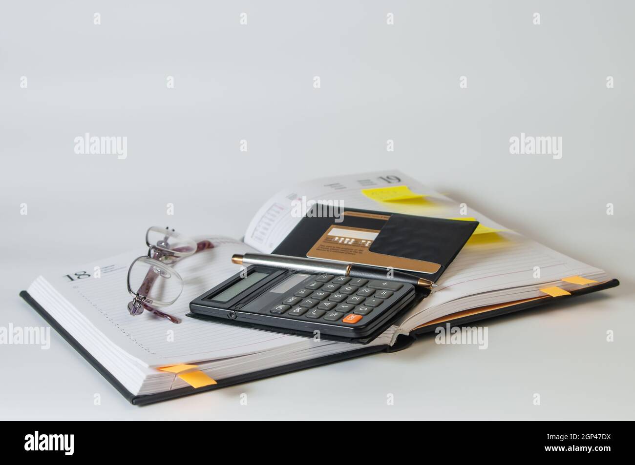 Diary, glasses, calculator, credit card and pen on a white background ...