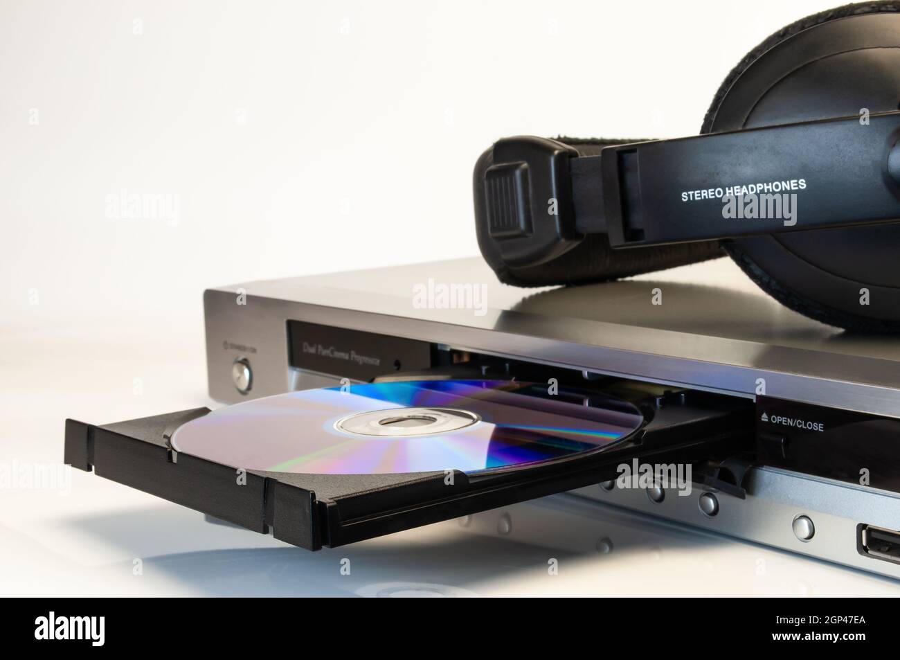 modern audio device with open tray, headphones and laserdisc on white ...