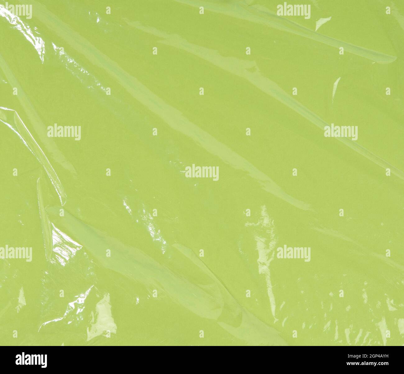 texture of crumpled transparent polyethylene on a green background ...