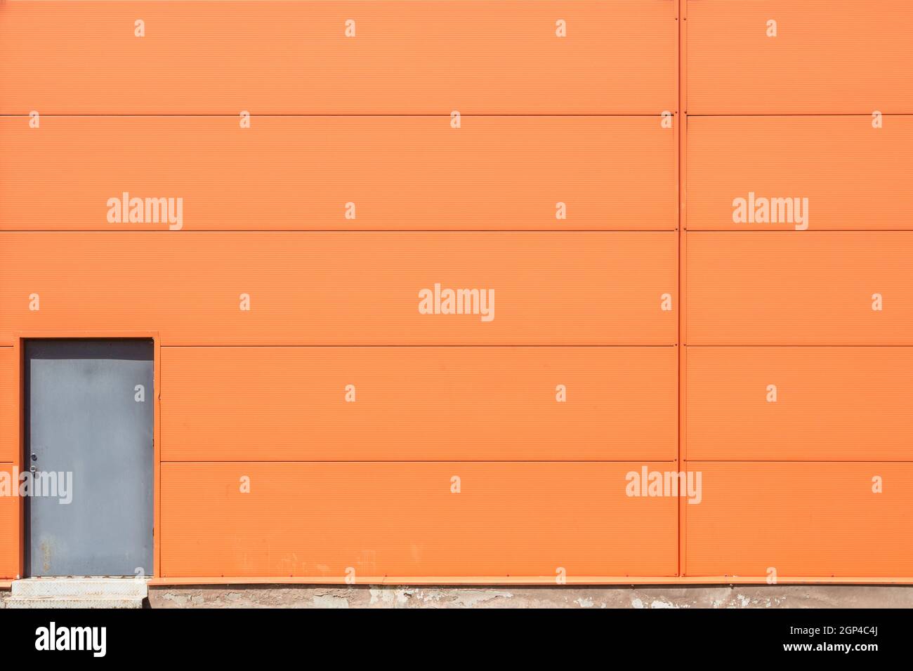 Modern orange building wall with metal doors Stock Photo - Alamy