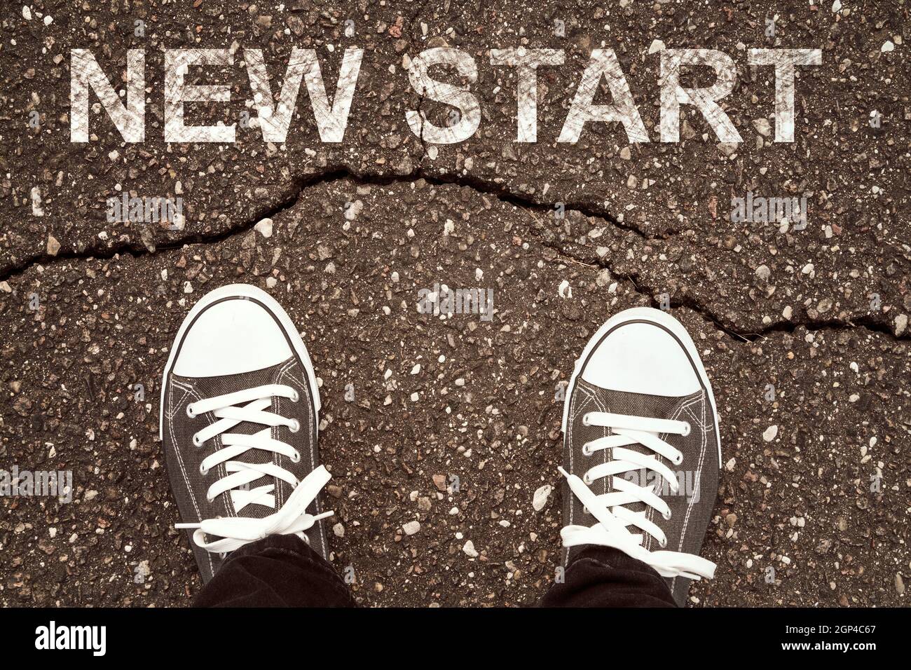 Man standing on cracked asphalt with NEW START sign Stock Photo - Alamy