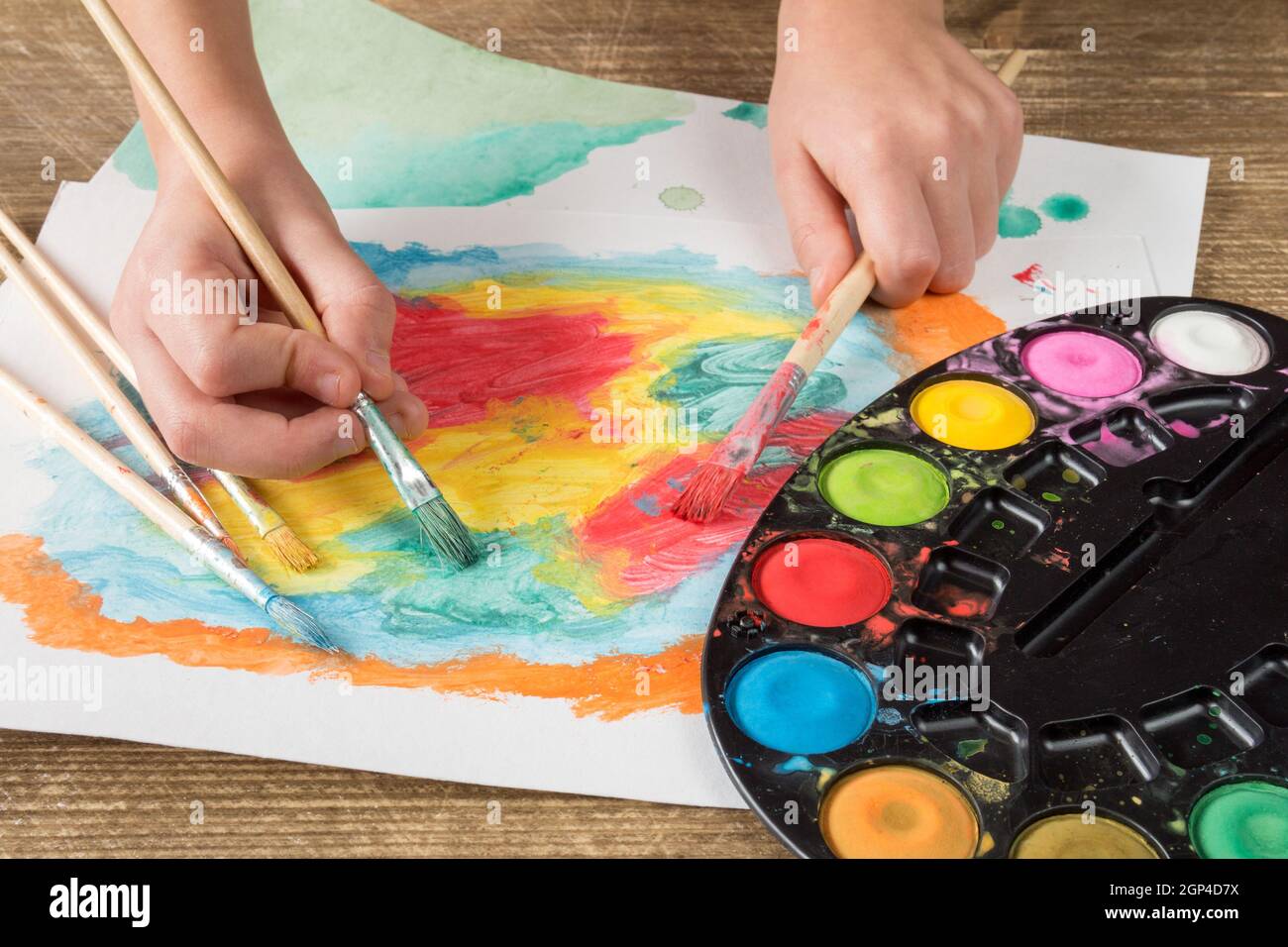 Child painting with paintbrush and colorful paints Stock Photo - Alamy