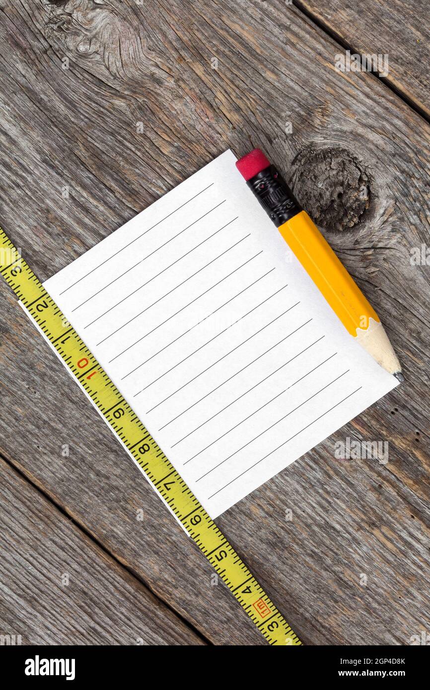 Note paper,pencil and tape measure on wooden texture Stock Photo - Alamy