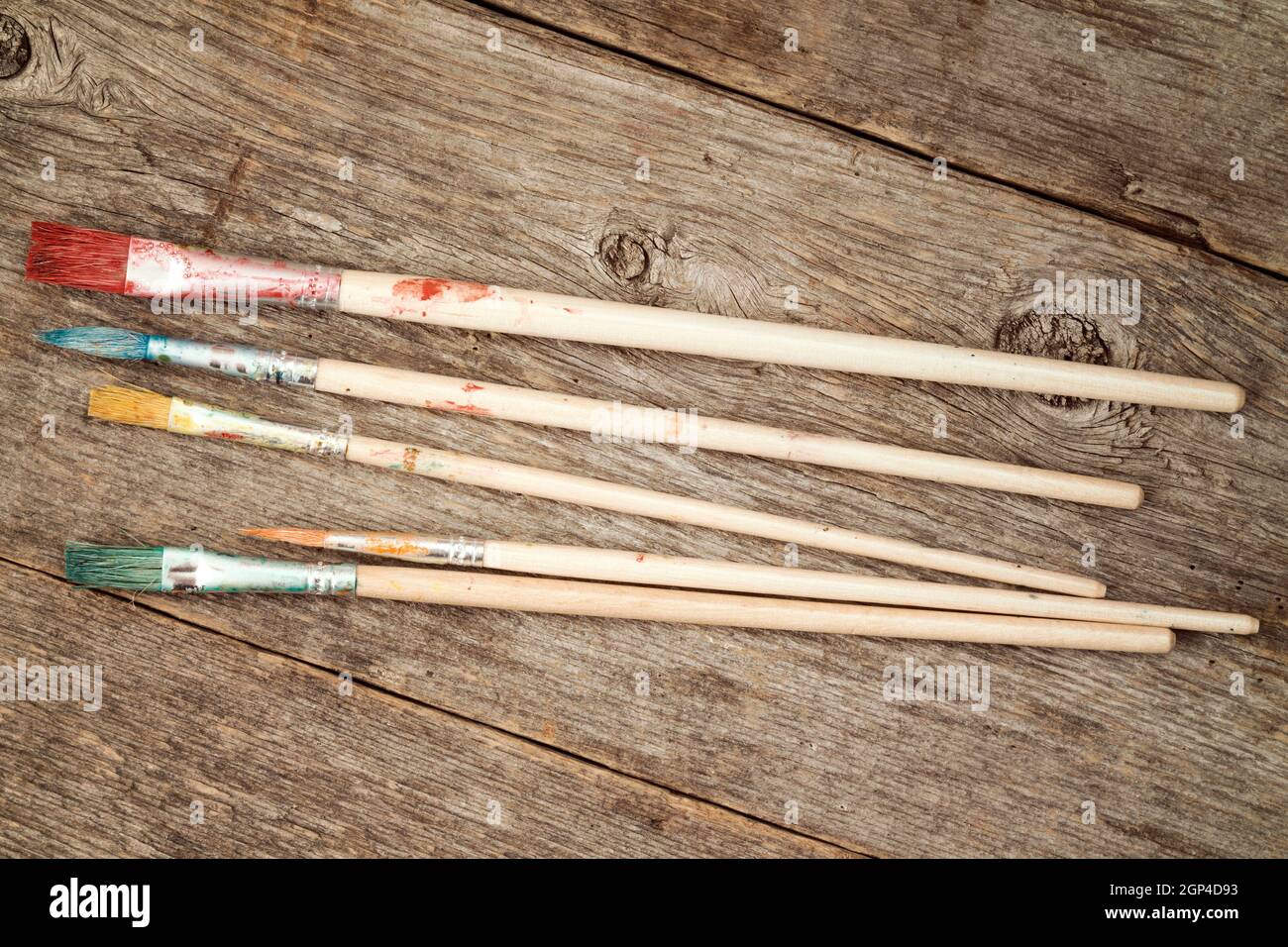 Set of dirty paint brushes on wooden background Stock Photo - Alamy
