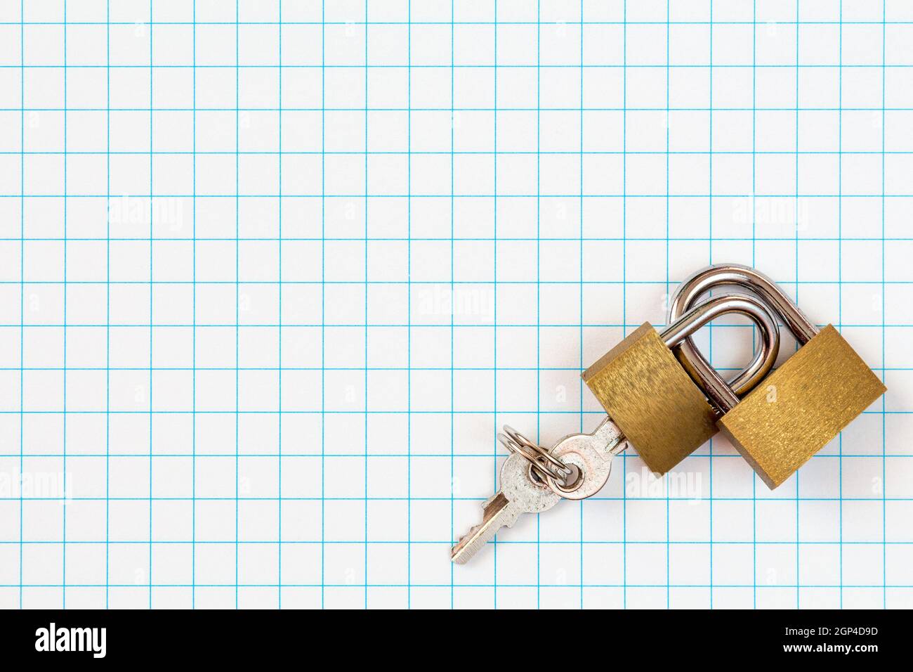 Two linked padlocks lying on squared paper background Stock Photo - Alamy