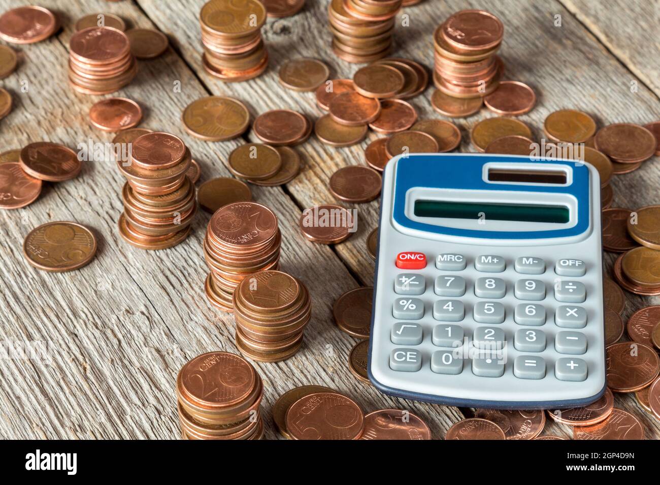 Digital calculator and coins stacked on wooden background Stock Photo ...