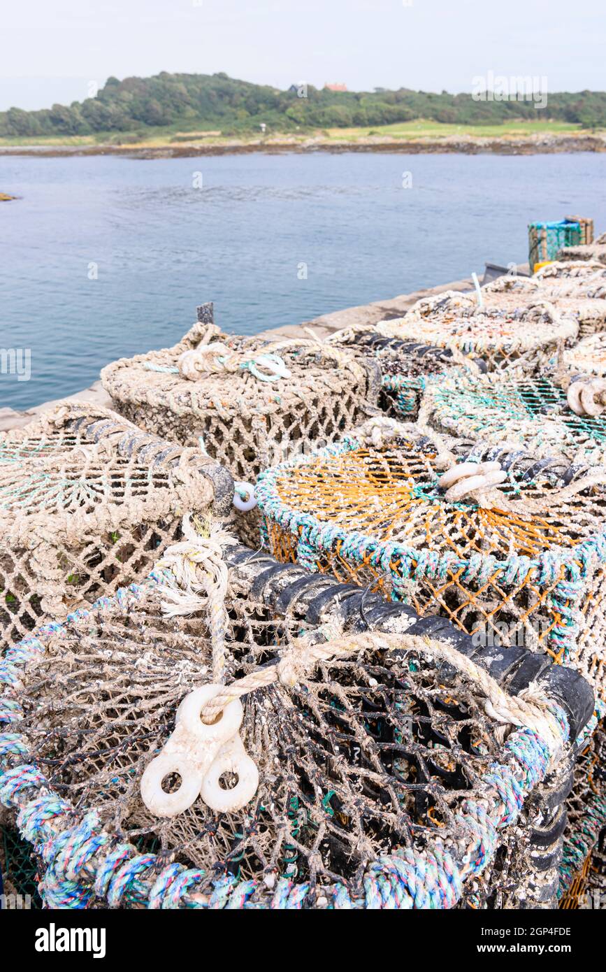 Traditional lobster cages sitting on a harbour beside the sea Stock ...