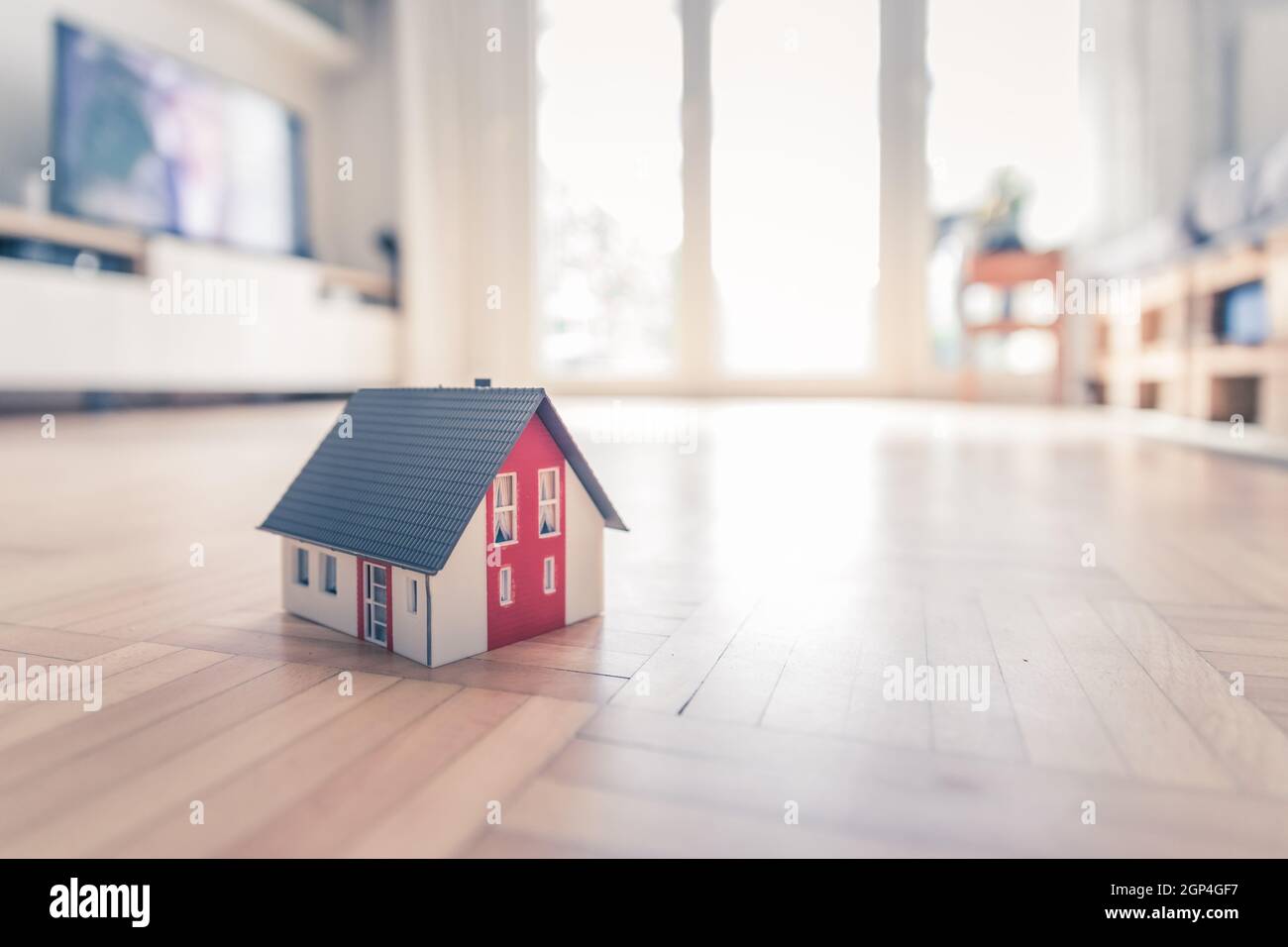 Red house model on the floor, indoors. Concept for new home, property ...