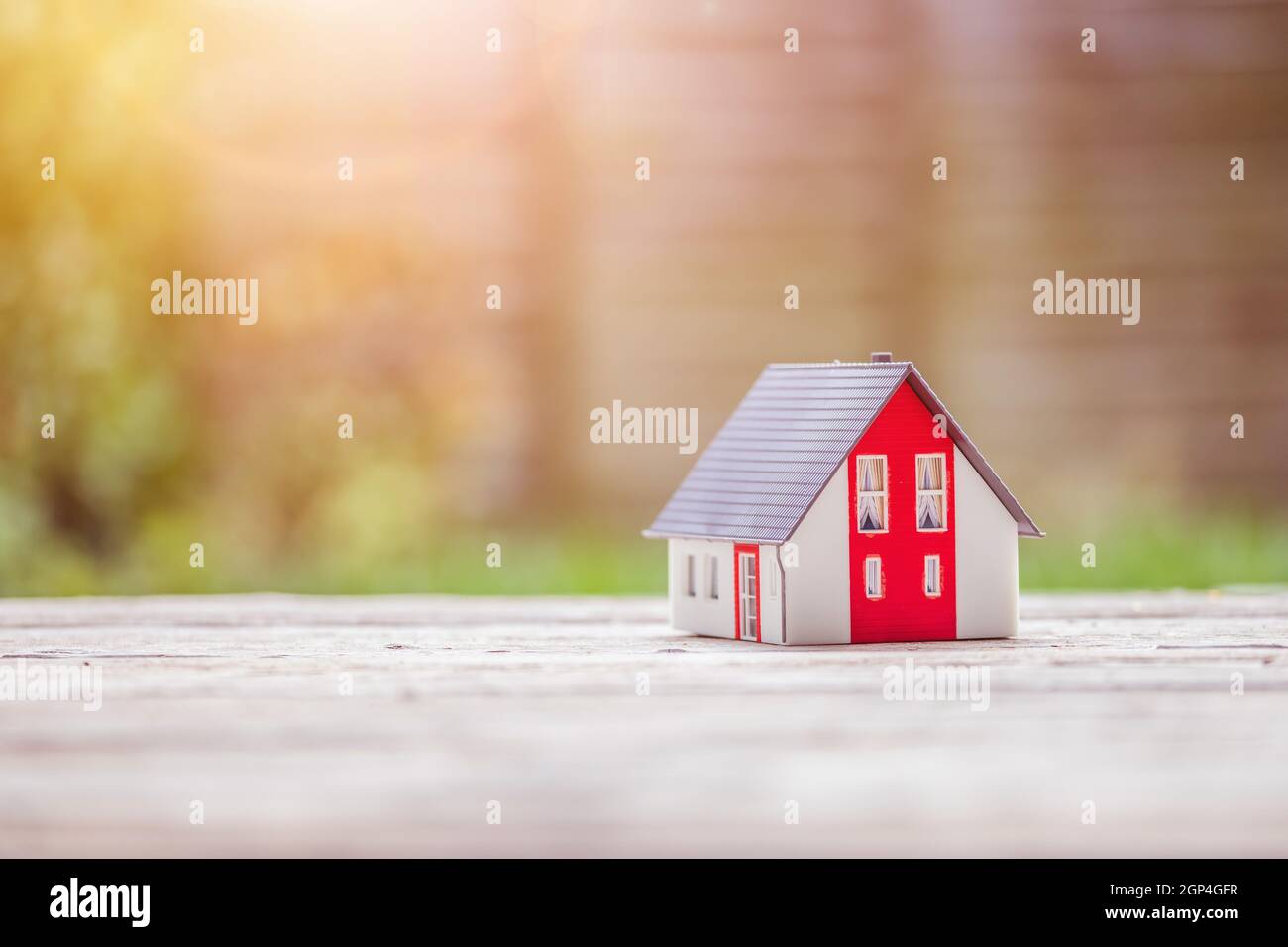 Red house model on the floor, outdoors. Concept for new home, property ...