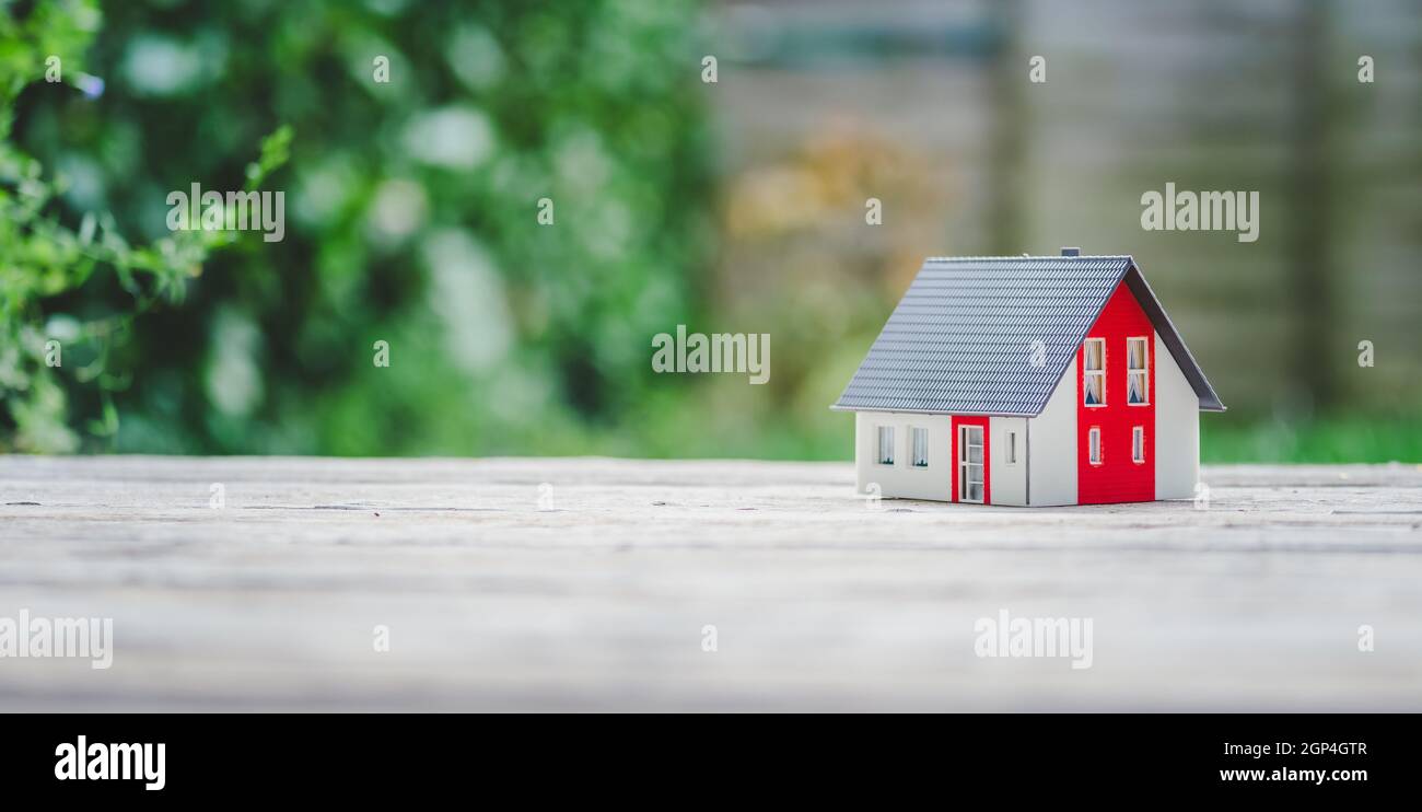 Red house model on the floor, outdoors. Concept for new home, property ...