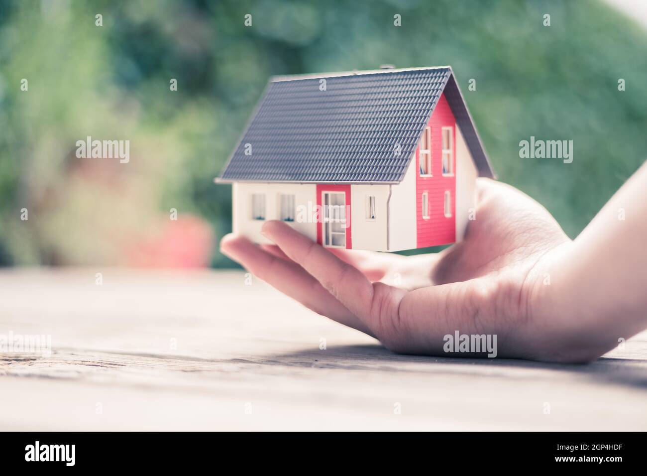 New home and house concept: Red house model outdoors in male hand Stock ...