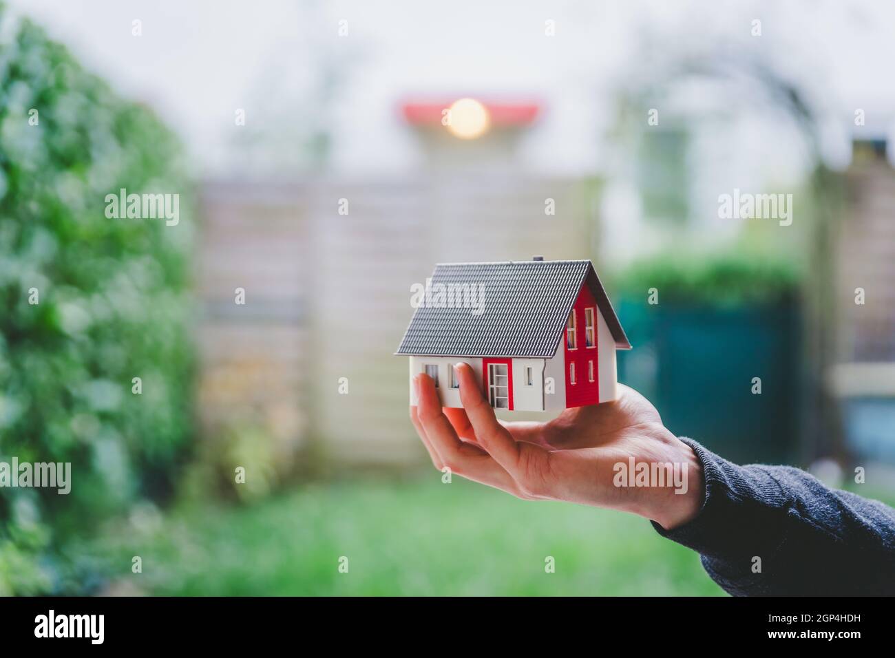 New home and house concept: Red house model outdoors in male hand Stock ...