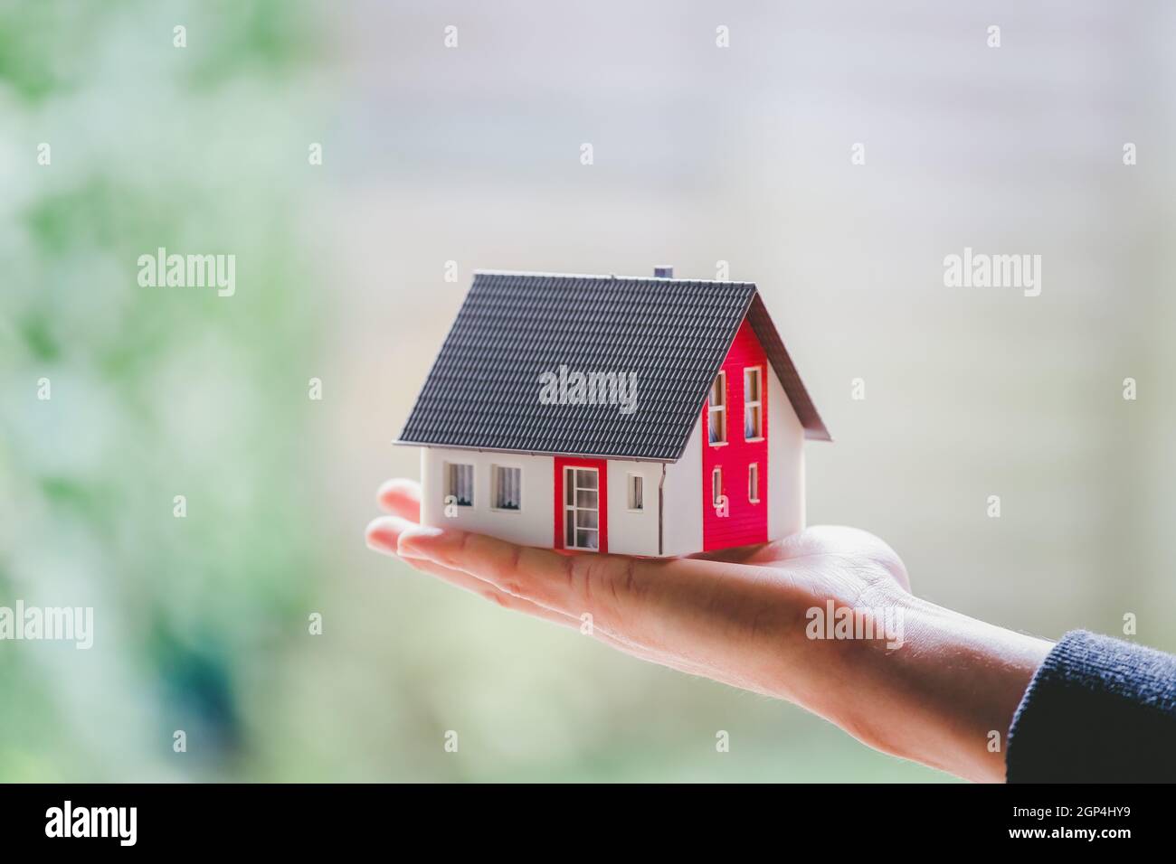 New home and house concept: Red house model outdoors in male hand Stock ...