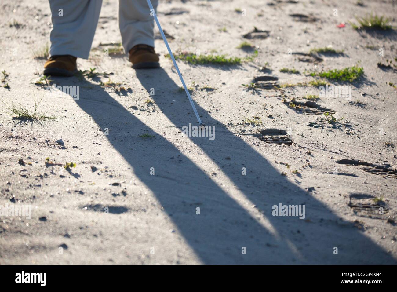 Close up of boots and a walking cane on a beach with tracks Stock Photo ...
