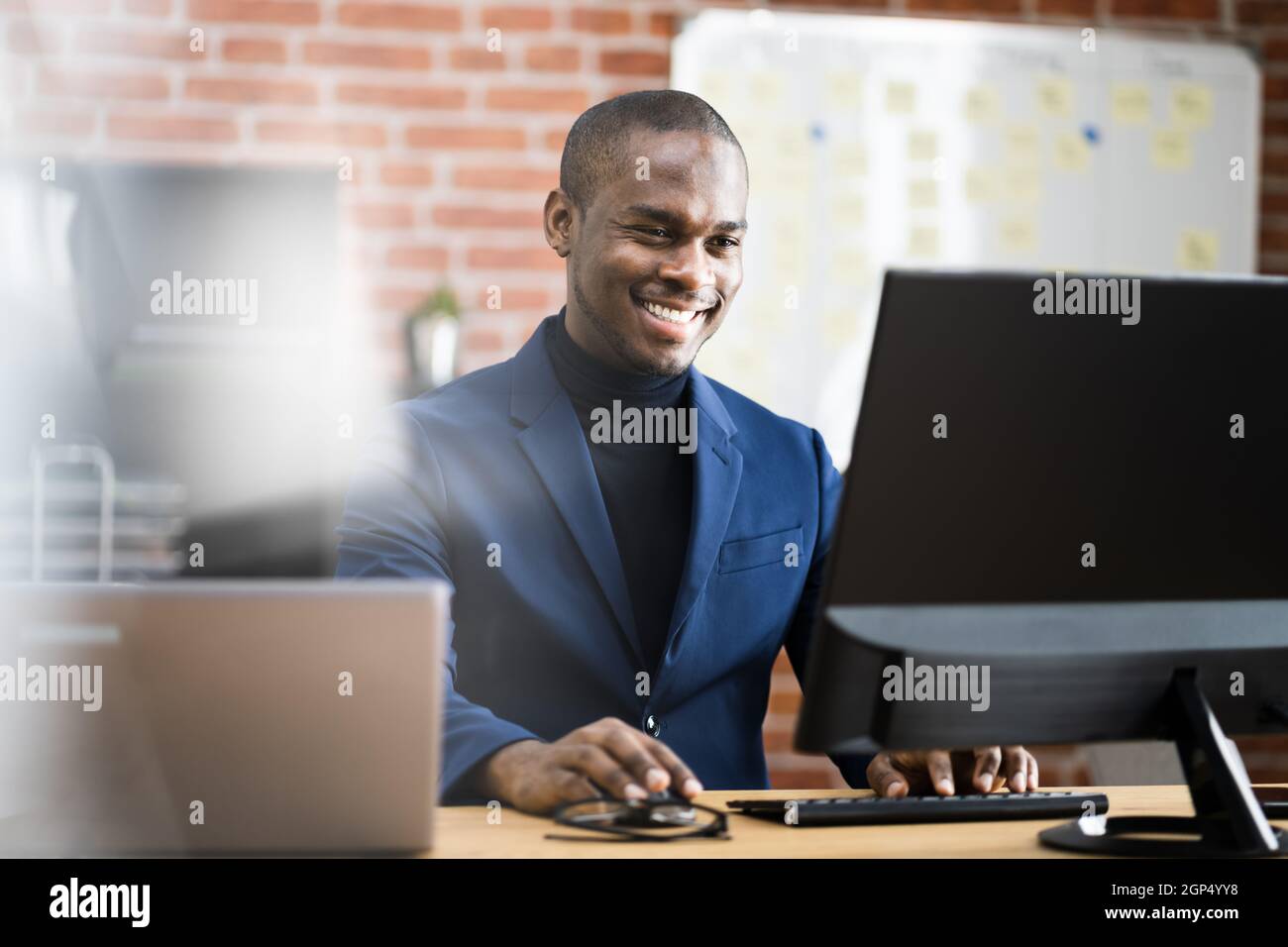 Happy Professional African Employee In Office Typing Stock Photo - Alamy
